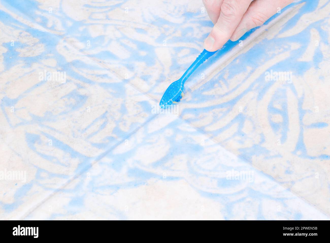 Scrubbing and cleaning floor tiles with a toothbrush Stock Photo - Alamy