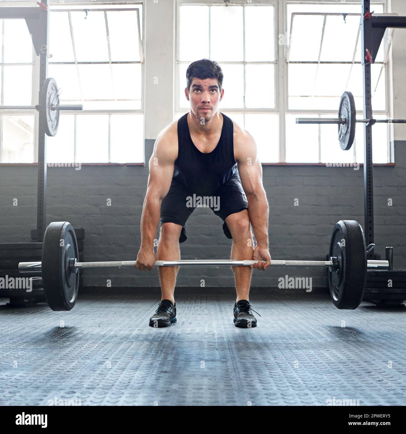 Straining through the lift. a young man working out with weights in the ...
