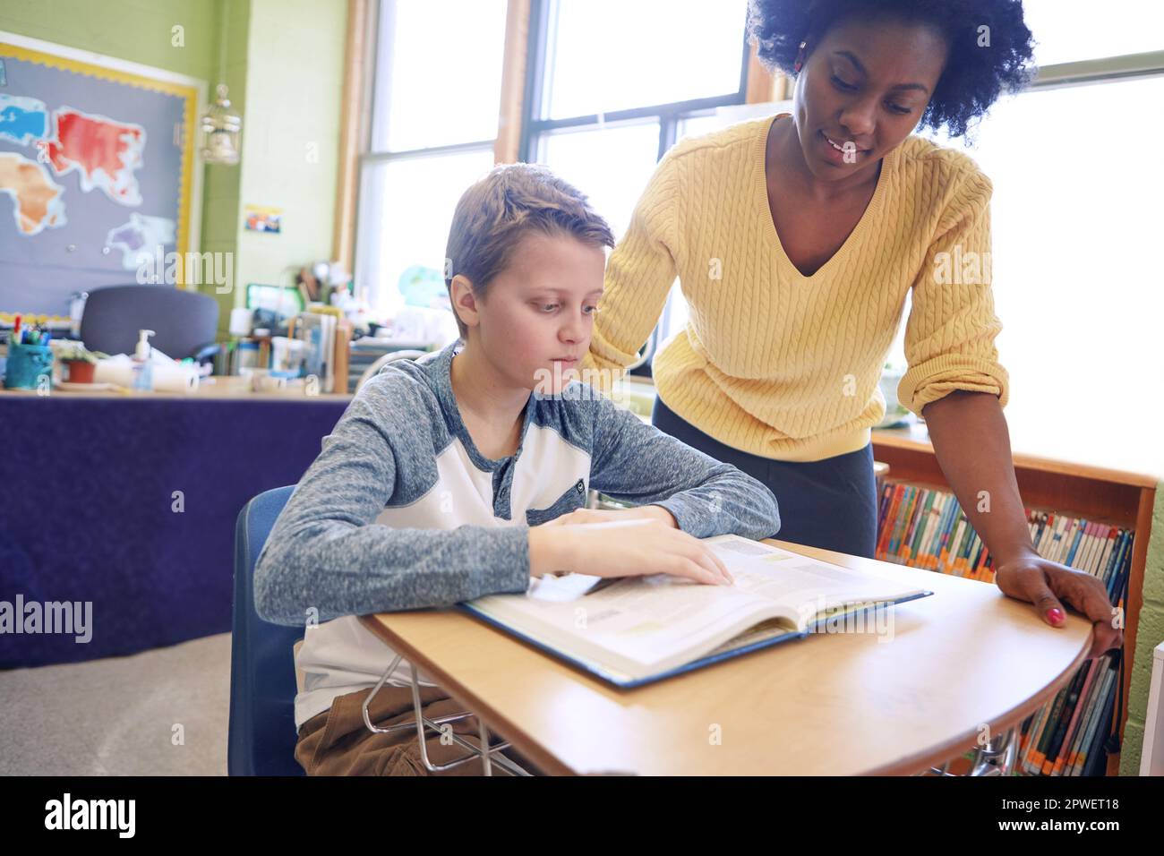 Practice makes progress not perfect. A young teacher assisting a ...