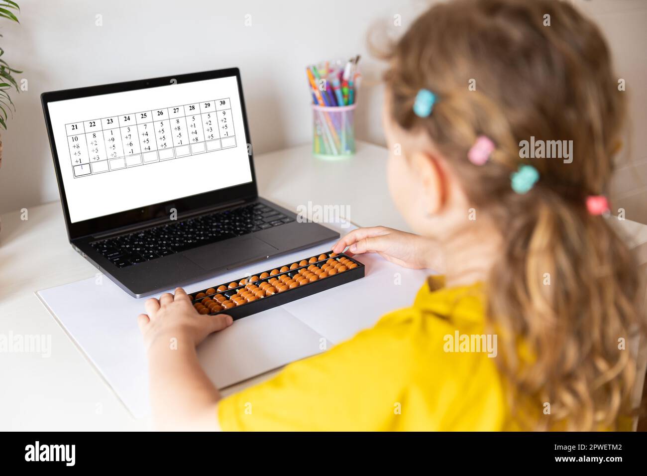 A girl from the back is engaged in mental arithmetic on the abacus ...