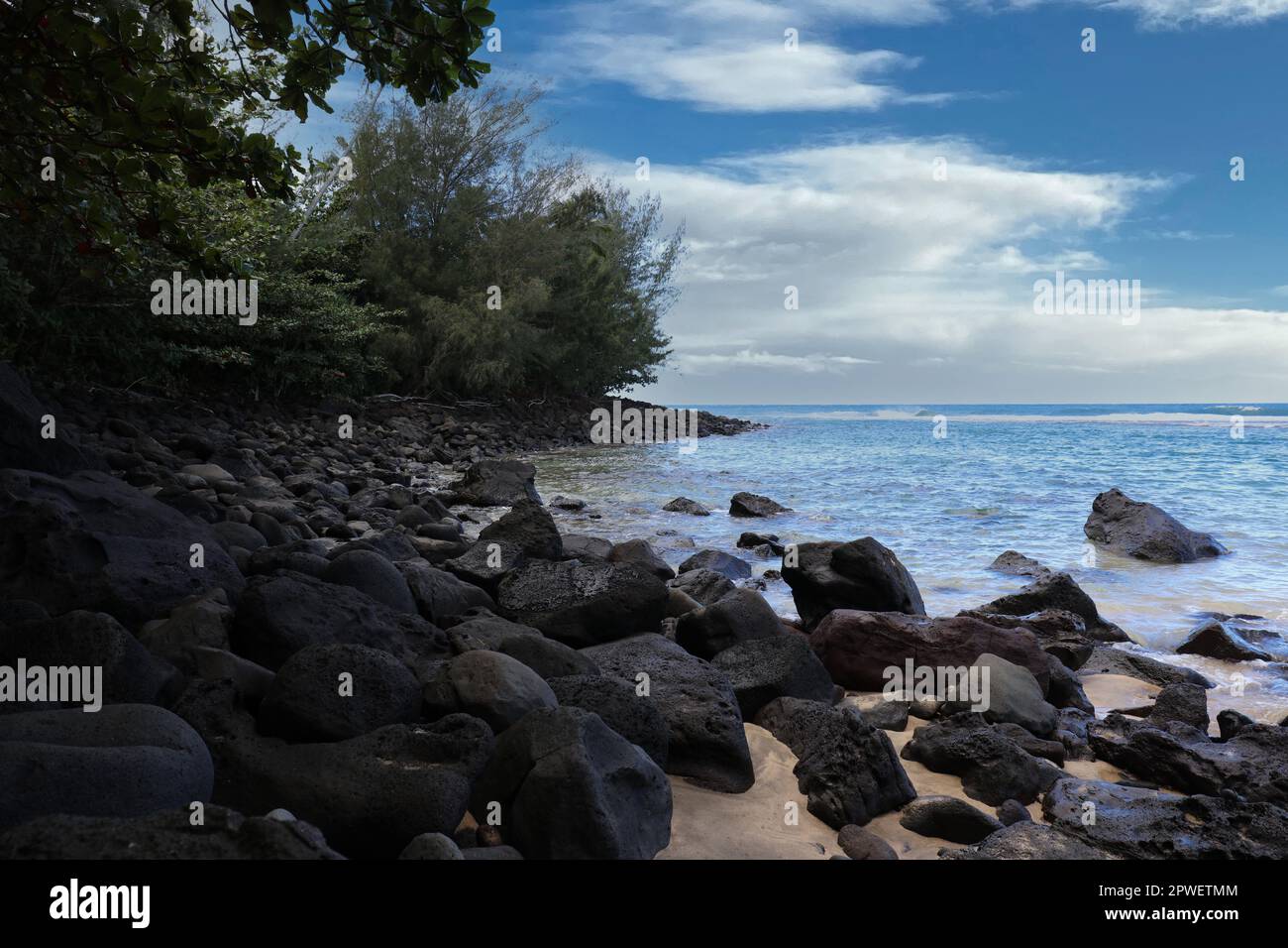 A mass of volcanic rock and boulders lining the shoreline at the south ...