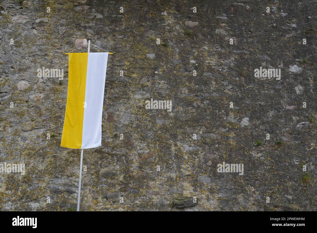 Flag of Roman Catholic Church in yellow and white hanging vertically on ...