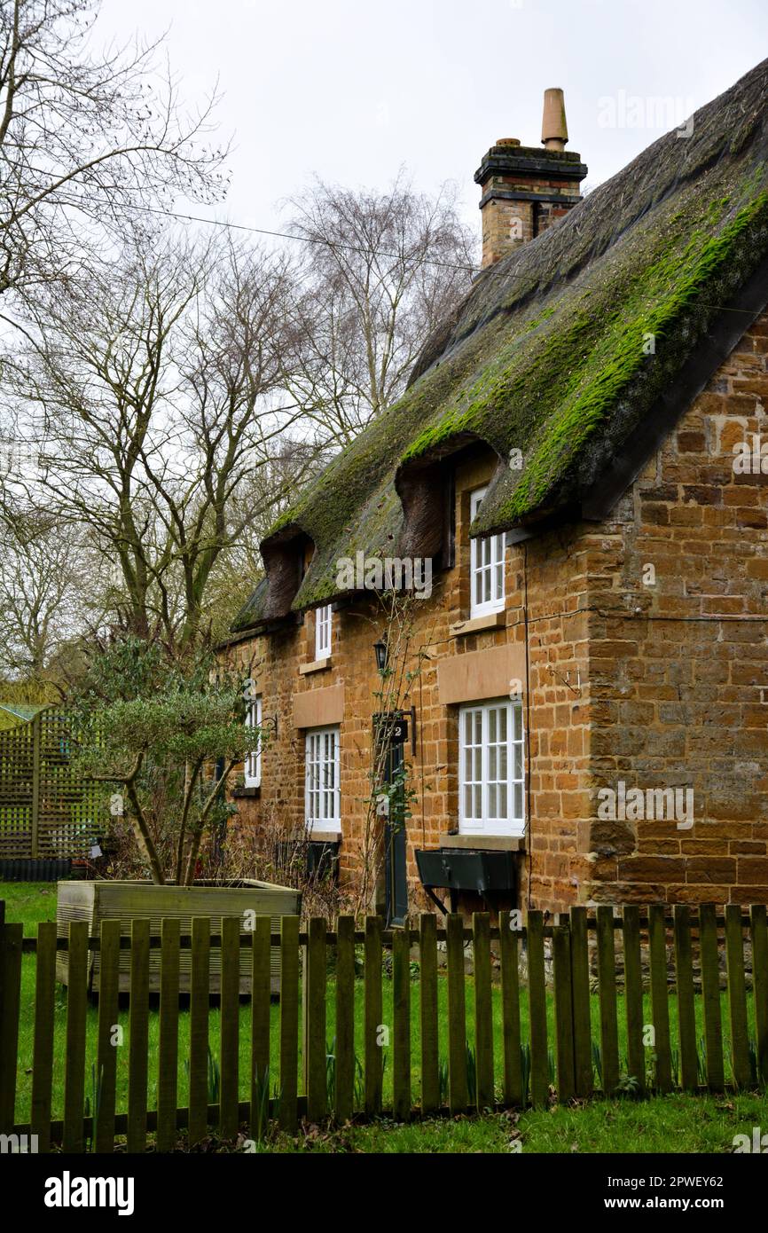 English thatched countryside cottage with white window frames and a ...