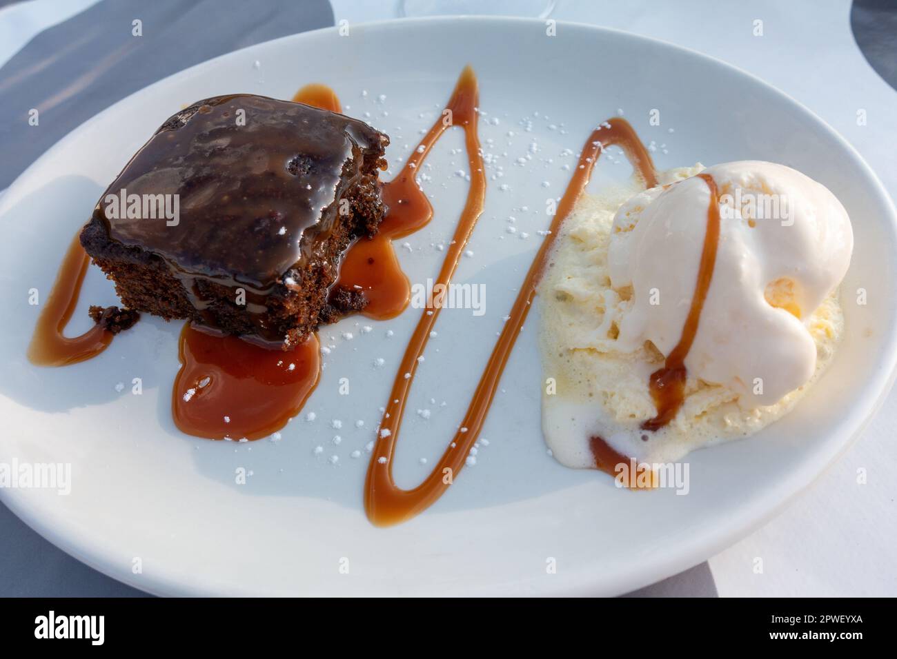 Sticky Toffee Pudding with Warm Toffee Sauce and Ice Cream is served in ...