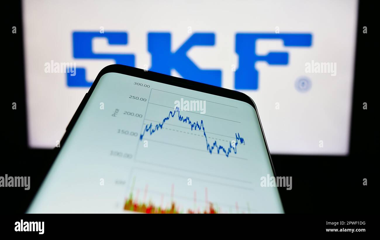 Mobile phone with website of Swedish bearing manufacturing company SKF AB on screen in front of ...