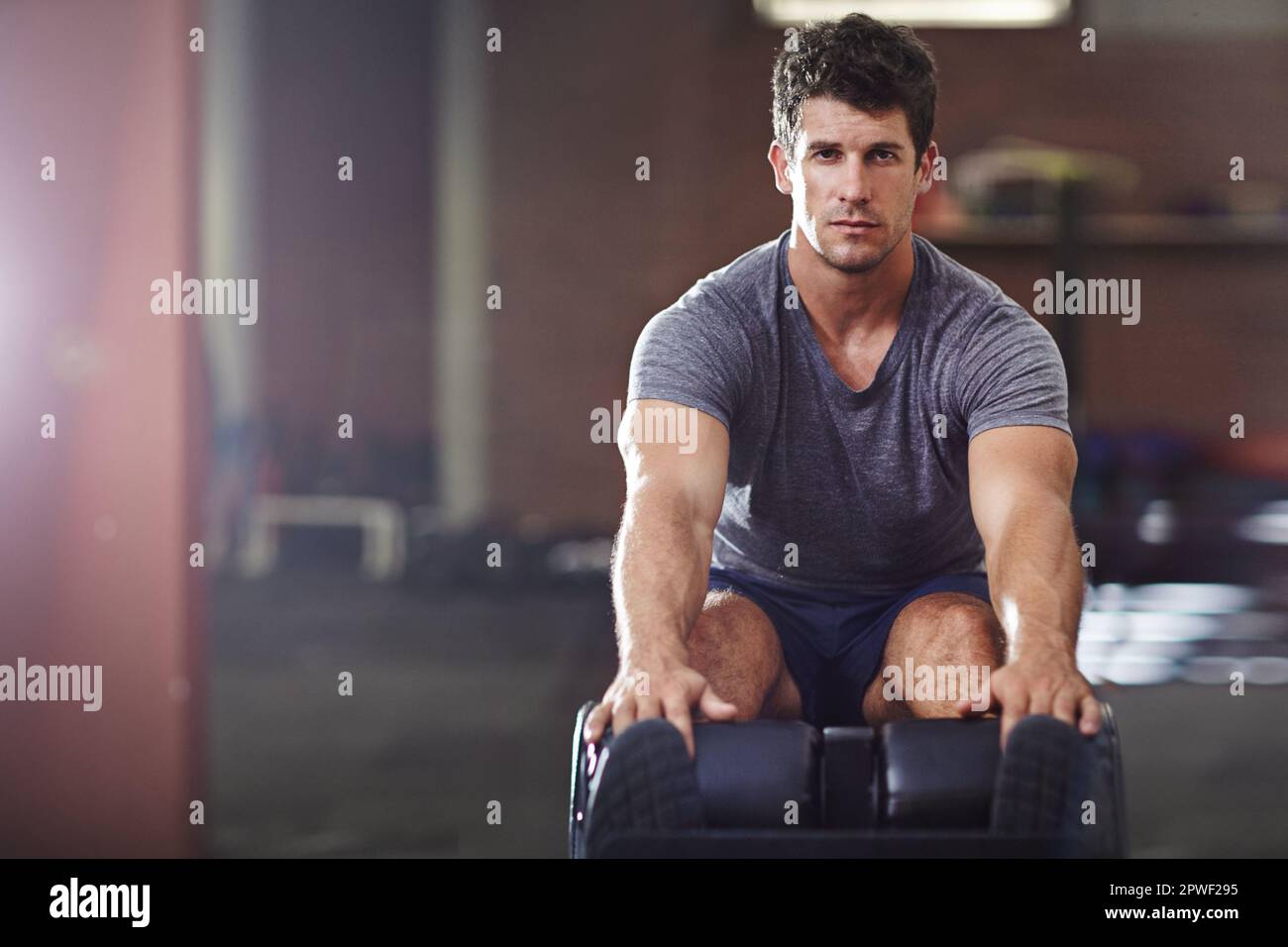 Working from the core out. a young man doing sit ups in a gym Stock ...