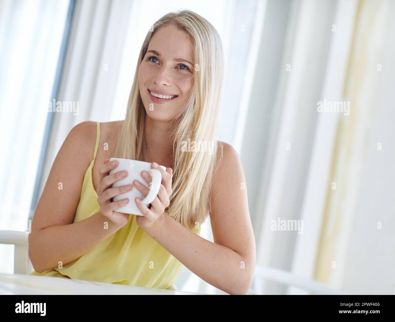 Getting started with a cup of java. an attractive young woman drinking ...