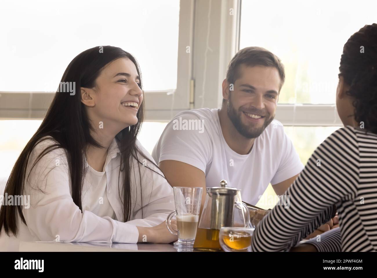 Group of friends sitting in cafeteria having pleasant conversation ...