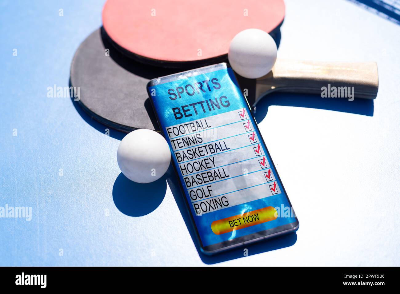 Smartphone on a blue table with ping pong rackets, rope and on ...