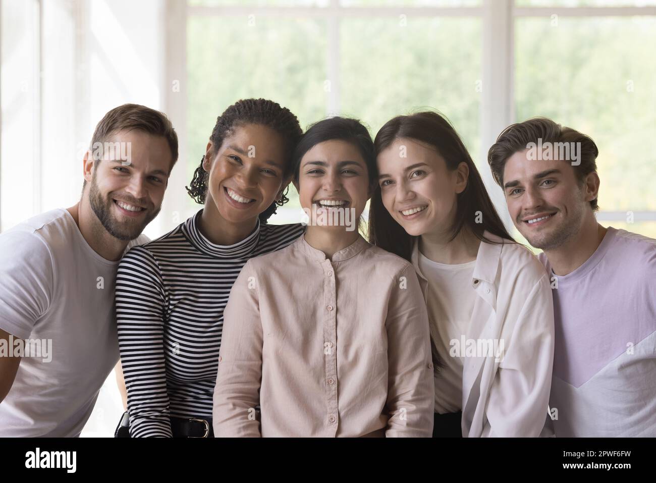 Happy diverse friends look at camera pose together indoors Stock Photo ...