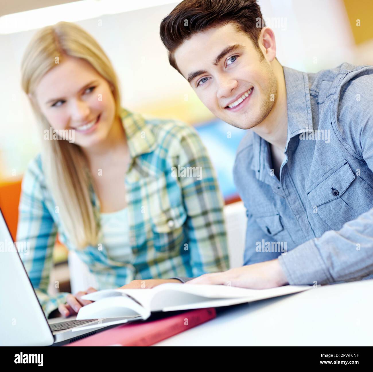 Helping a friend with her homework. Two smiling students helping each ...