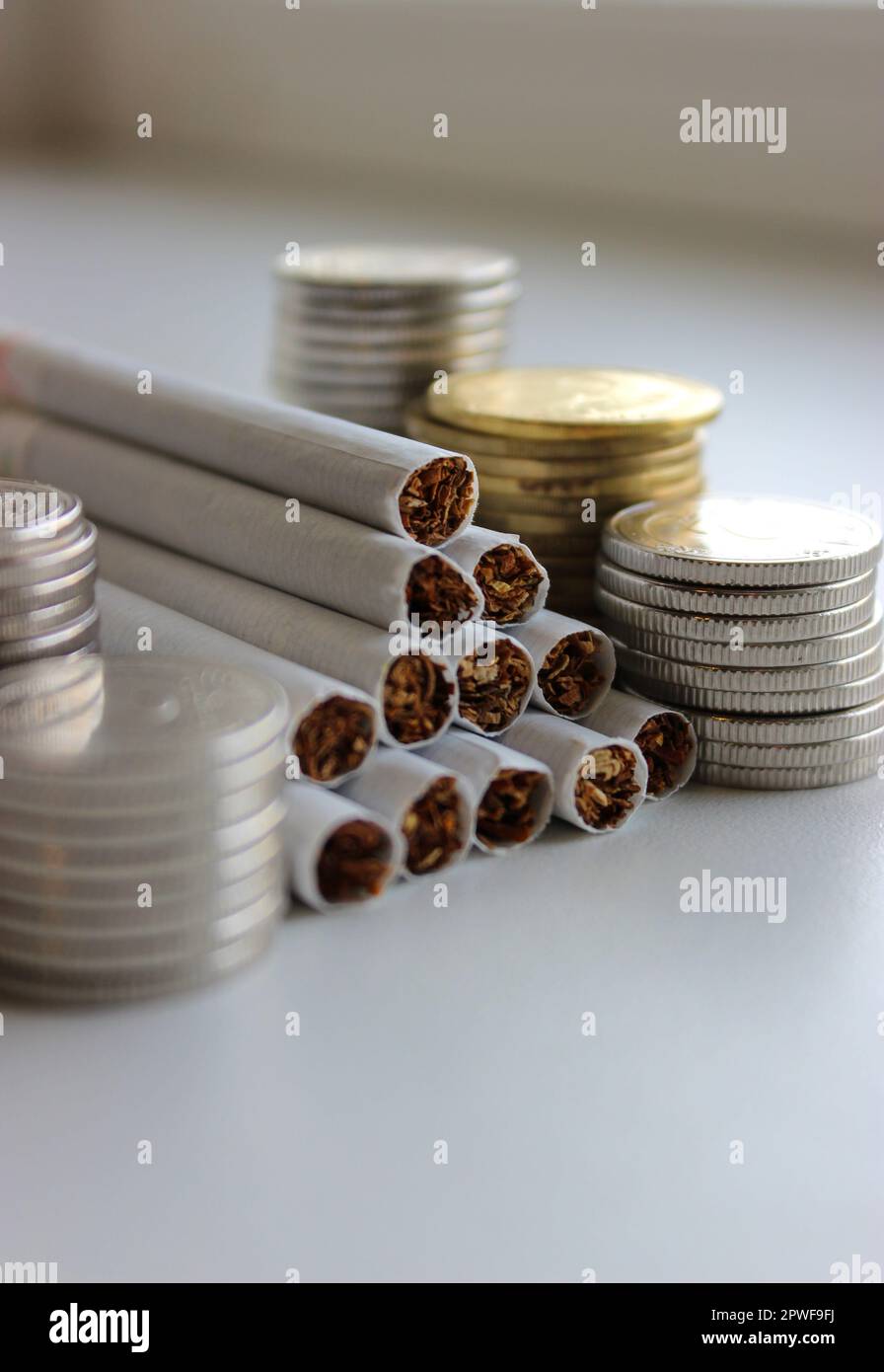 Scattered cigarettes are clamped between the columns of coins ...