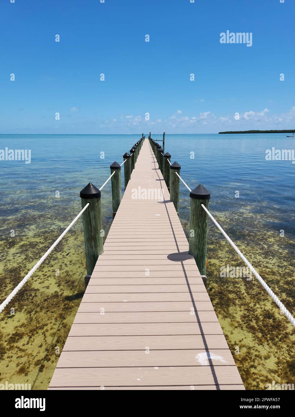 Tavernier, Florida - April 2, 2023 - Long dock extends into clear calm ...