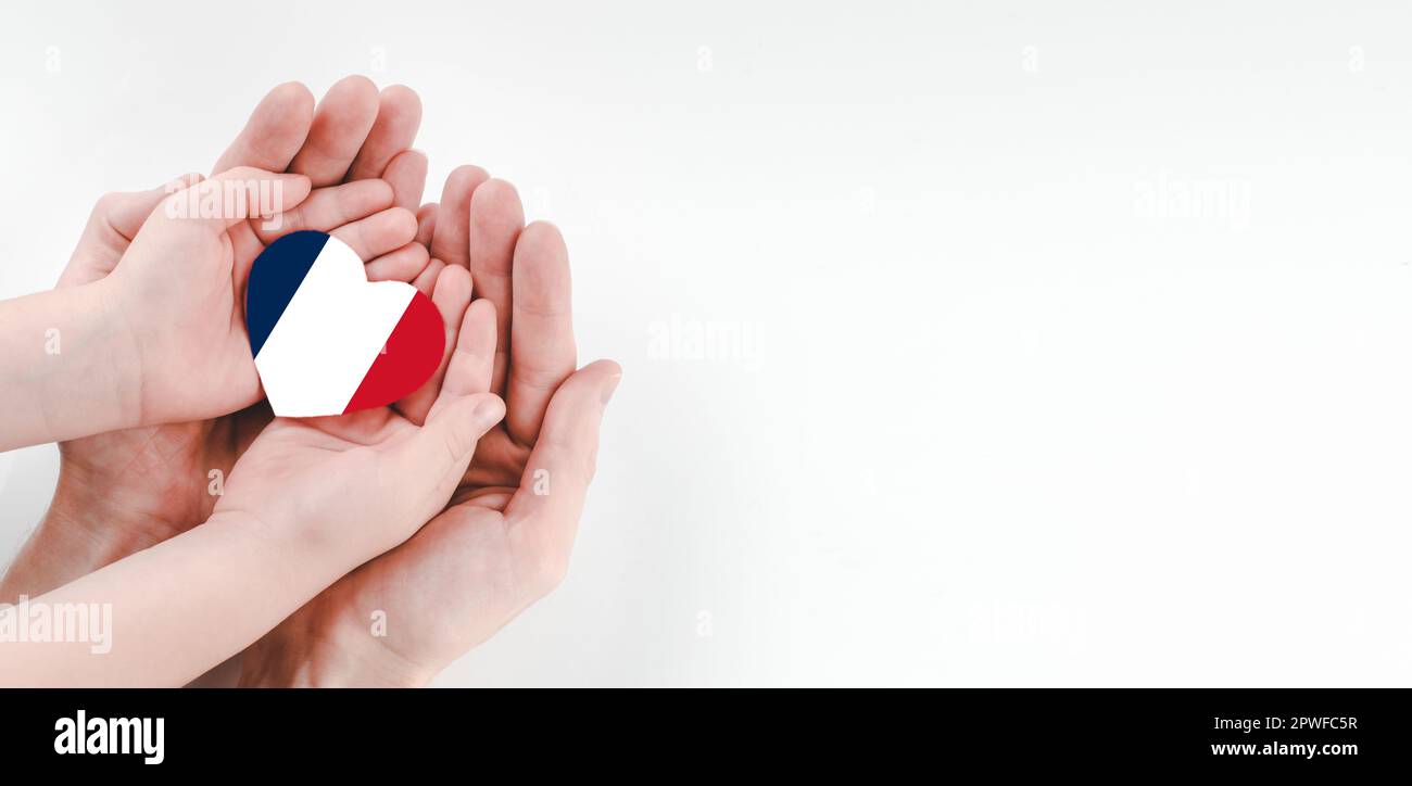The hands of father and son hold the flag of France in the shape of a ...