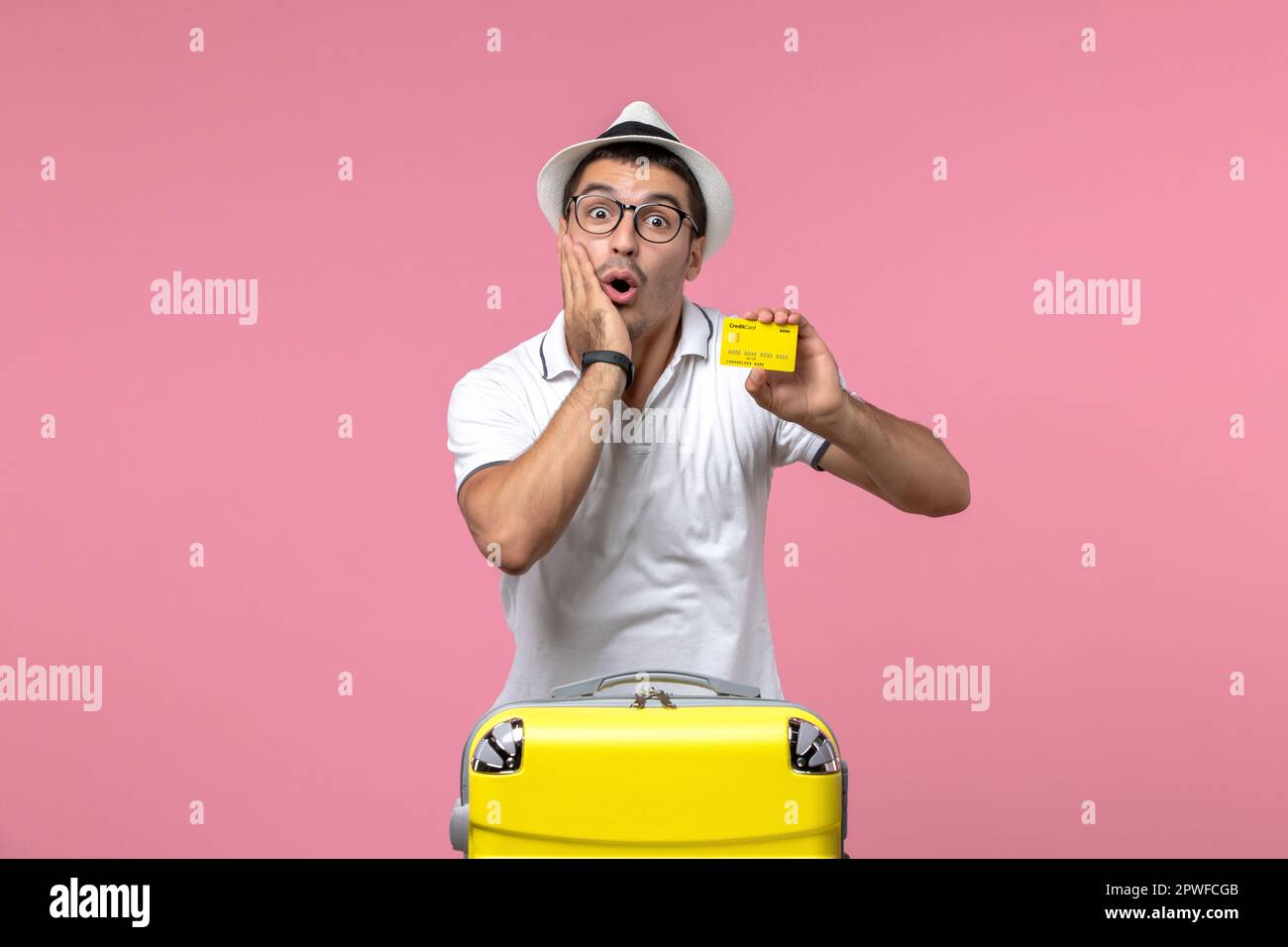 front view young male holding yellow bank card on the light pink ...