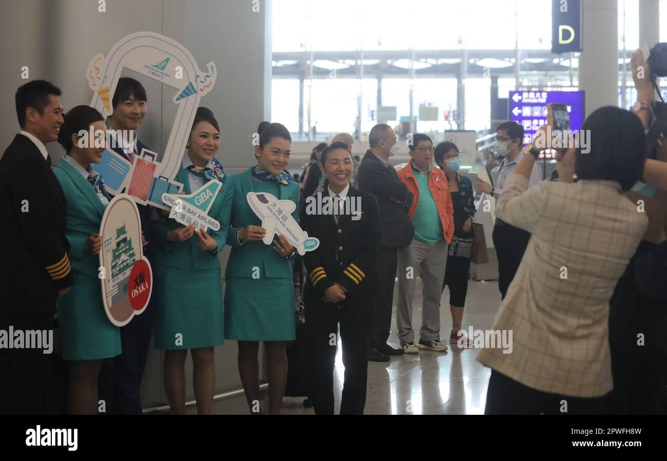 Greater Bay Airlines (GBA) crew members welcome passengers to check in ...
