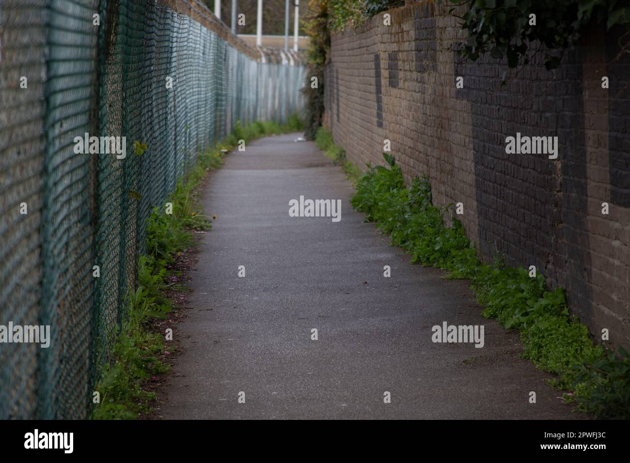 Narrow pedestrian alley, leading to Gunnersbury Station, Chiswick, West ...