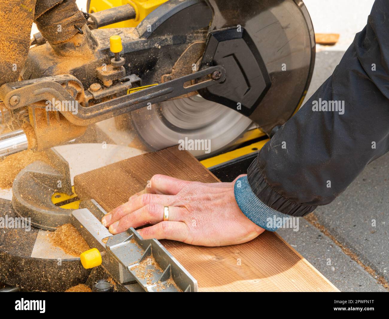 Man working with circular blade saw for cutting wood beam. Close up ...