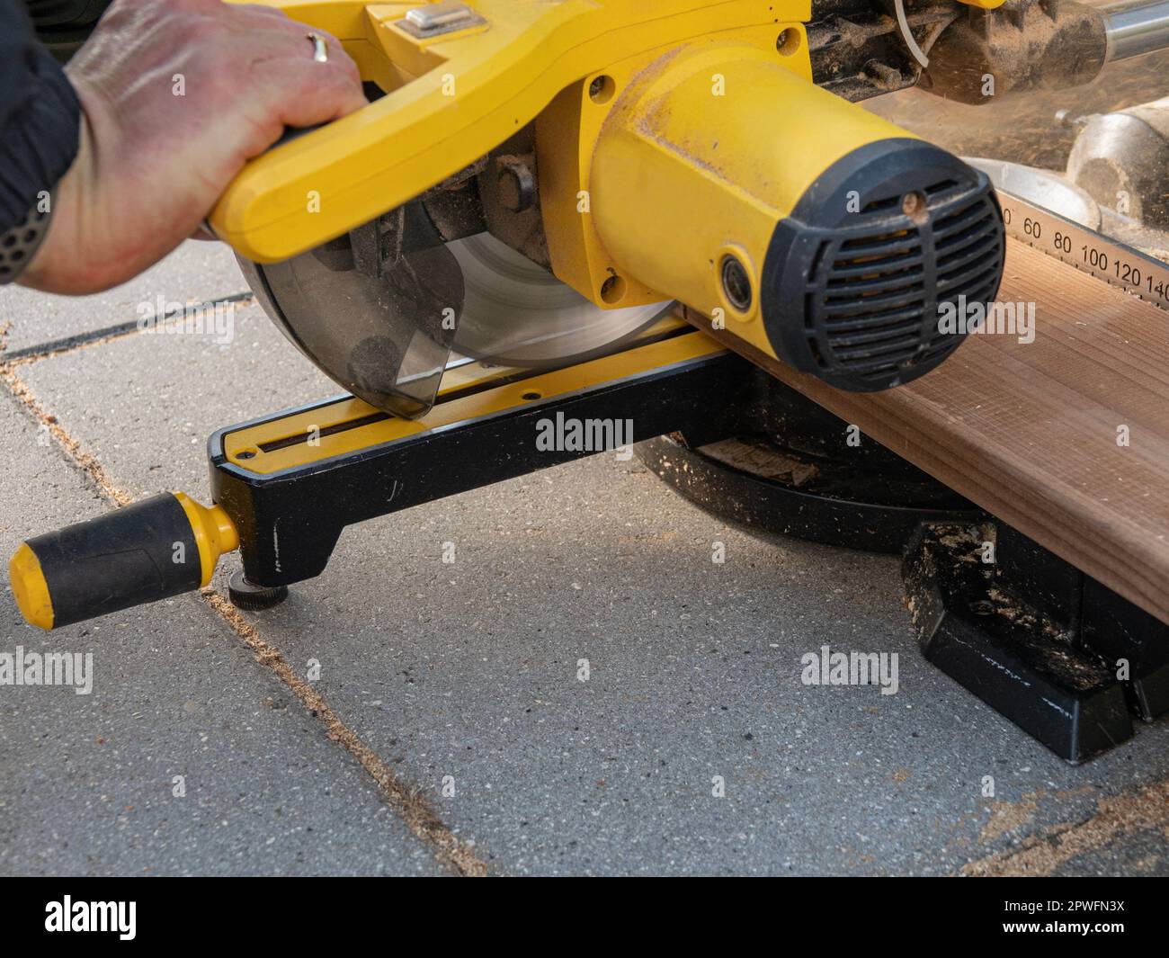 Man working with circular blade saw for cutting wood beam. Close up ...