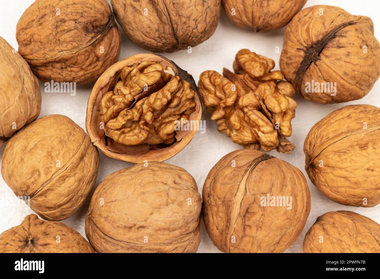 Walnut kernels and whole nuts are scattered on the table. Flat lay ...