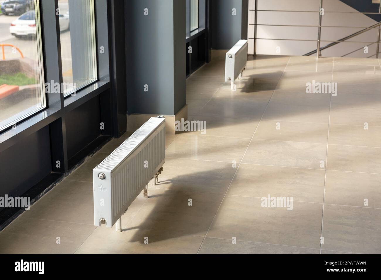 Vertically installed central heating radiator on the floor at the fully ...