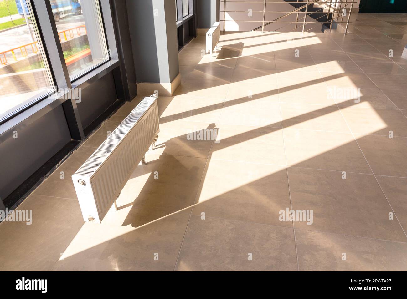 Vertically installed central heating radiator on the floor at the fully ...