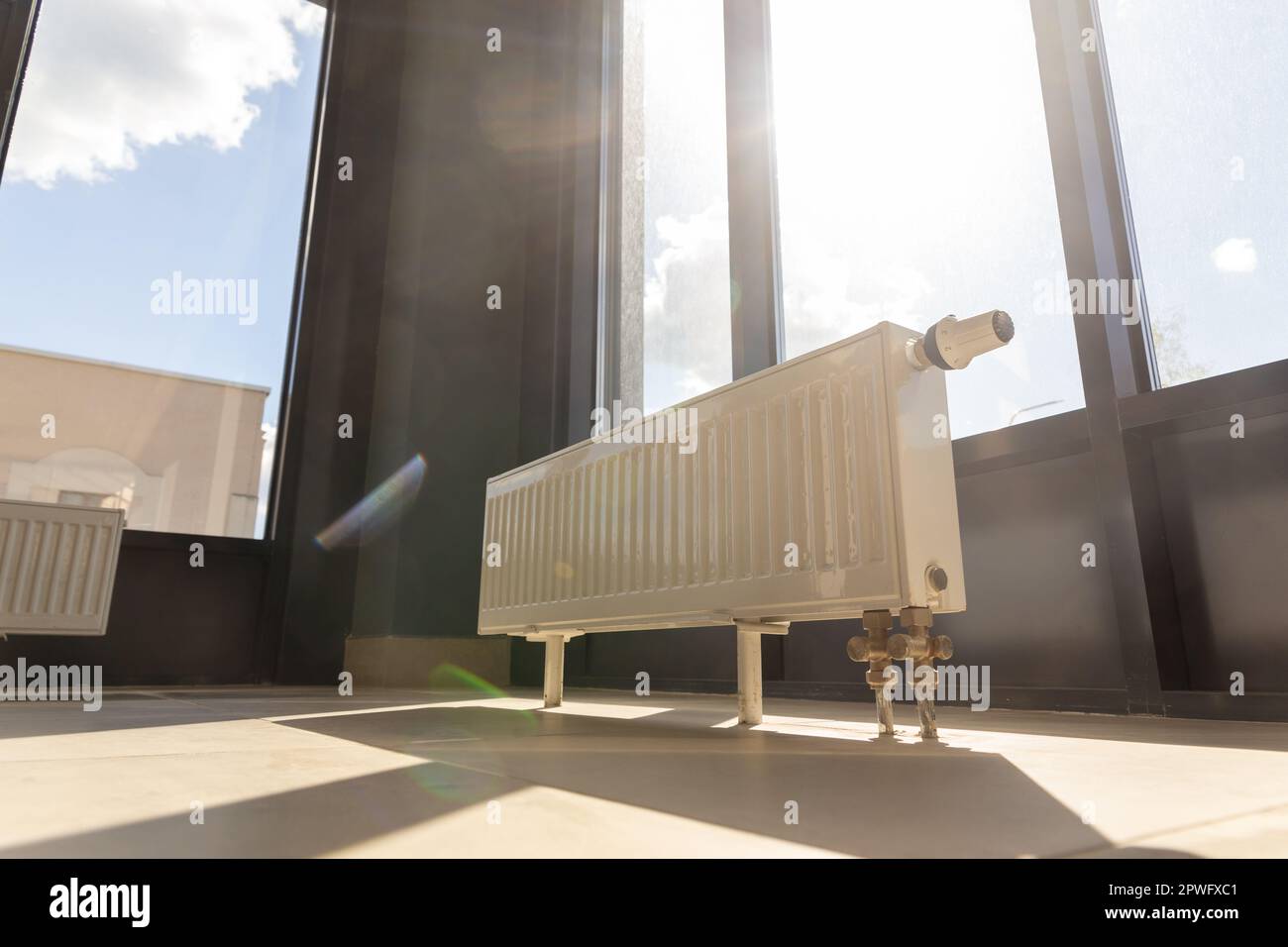 Vertically installed central heating radiator on the floor at the fully ...