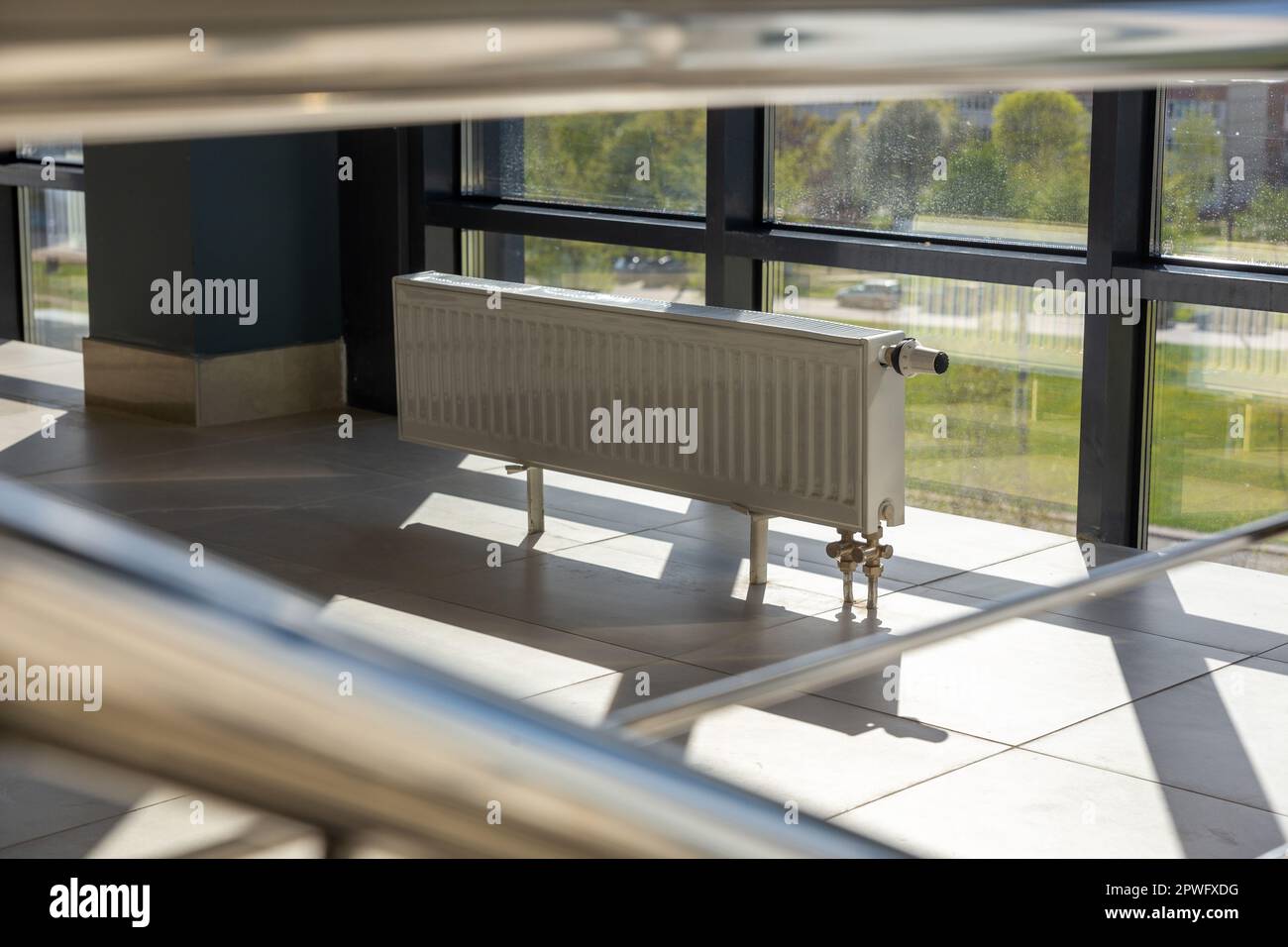 Vertically installed central heating radiator on the floor at the fully ...