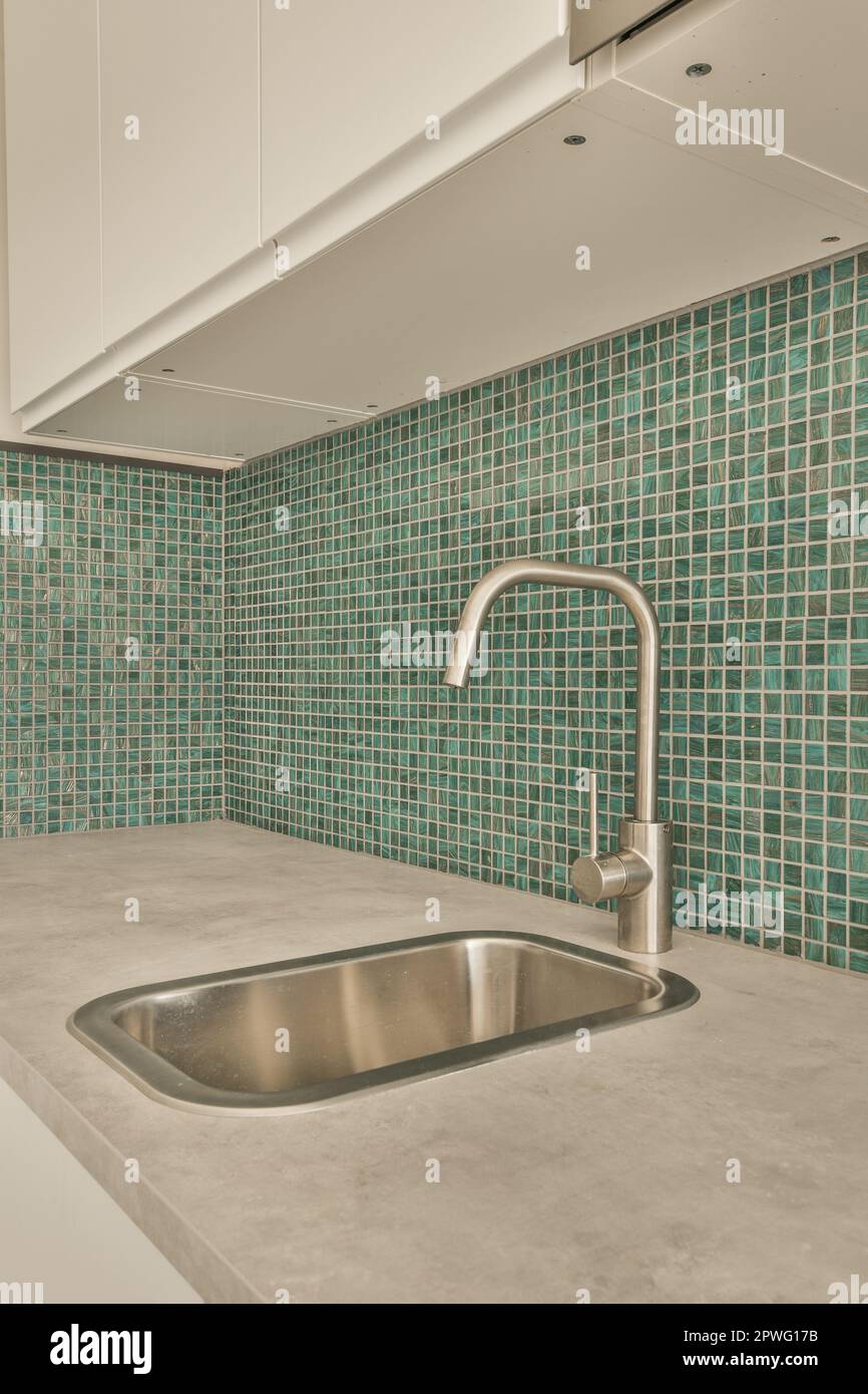a kitchen with green tiles on the backs and white cabinets in the photo ...