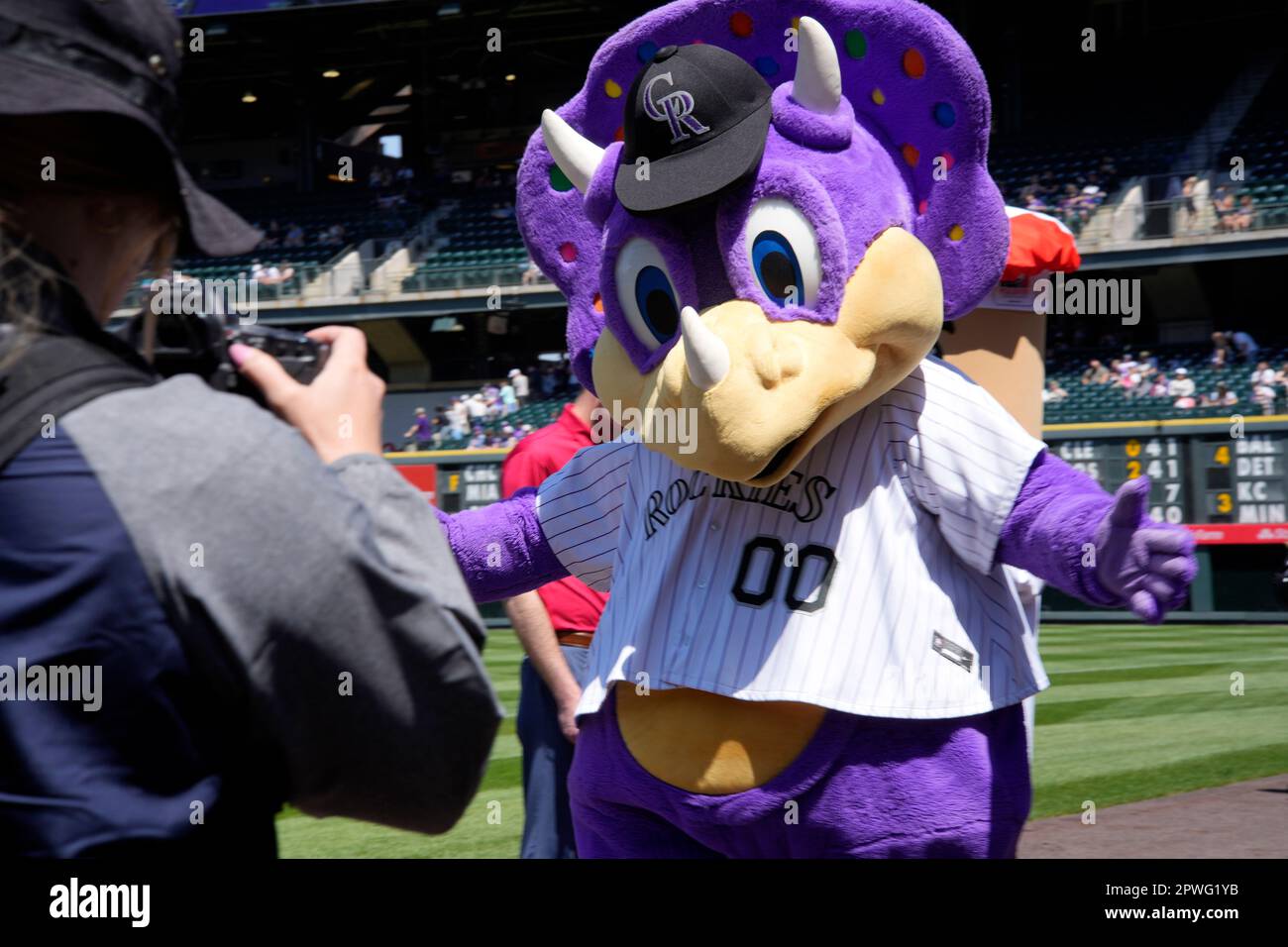 Colorado Rockies mascot Dinger the dinosaur parades around the warning ...