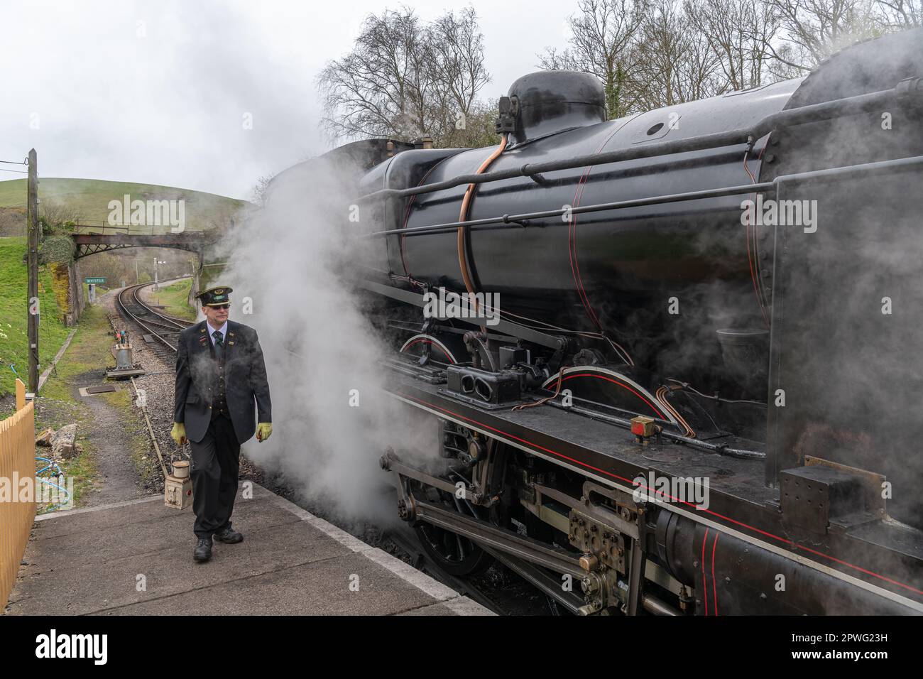Train Guard carrying the Last Carriage Lamp beside a steam Locomotive ...