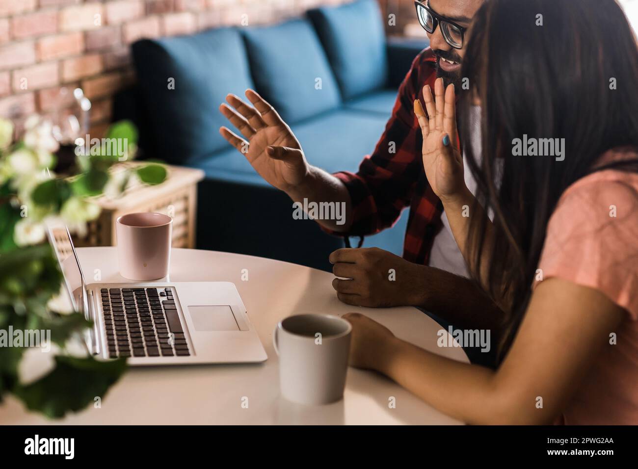 Happy indian family couple cuddle at desk make video call to friends ...