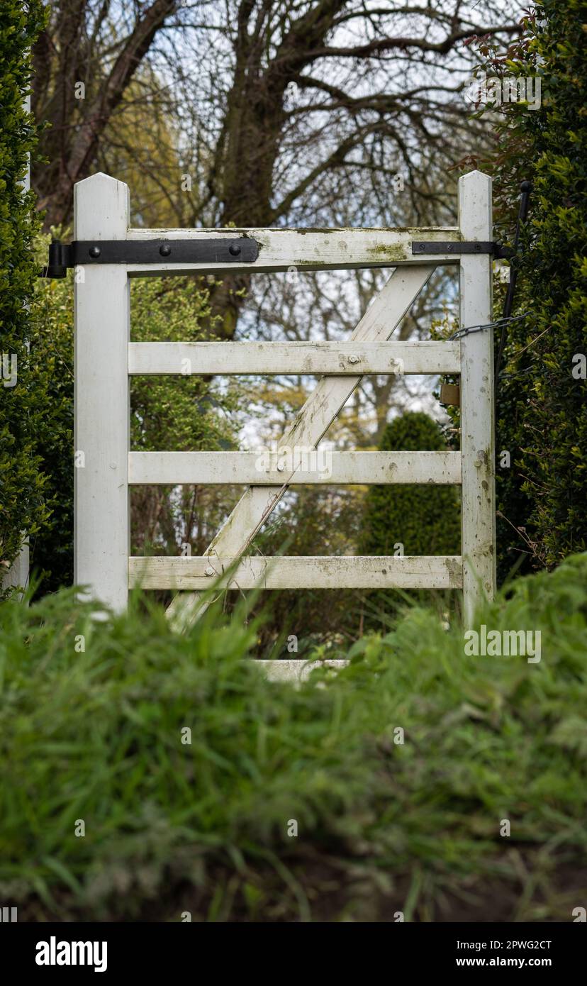 A Peaceful Spring Day with a white garden gate with piling paint Stock ...
