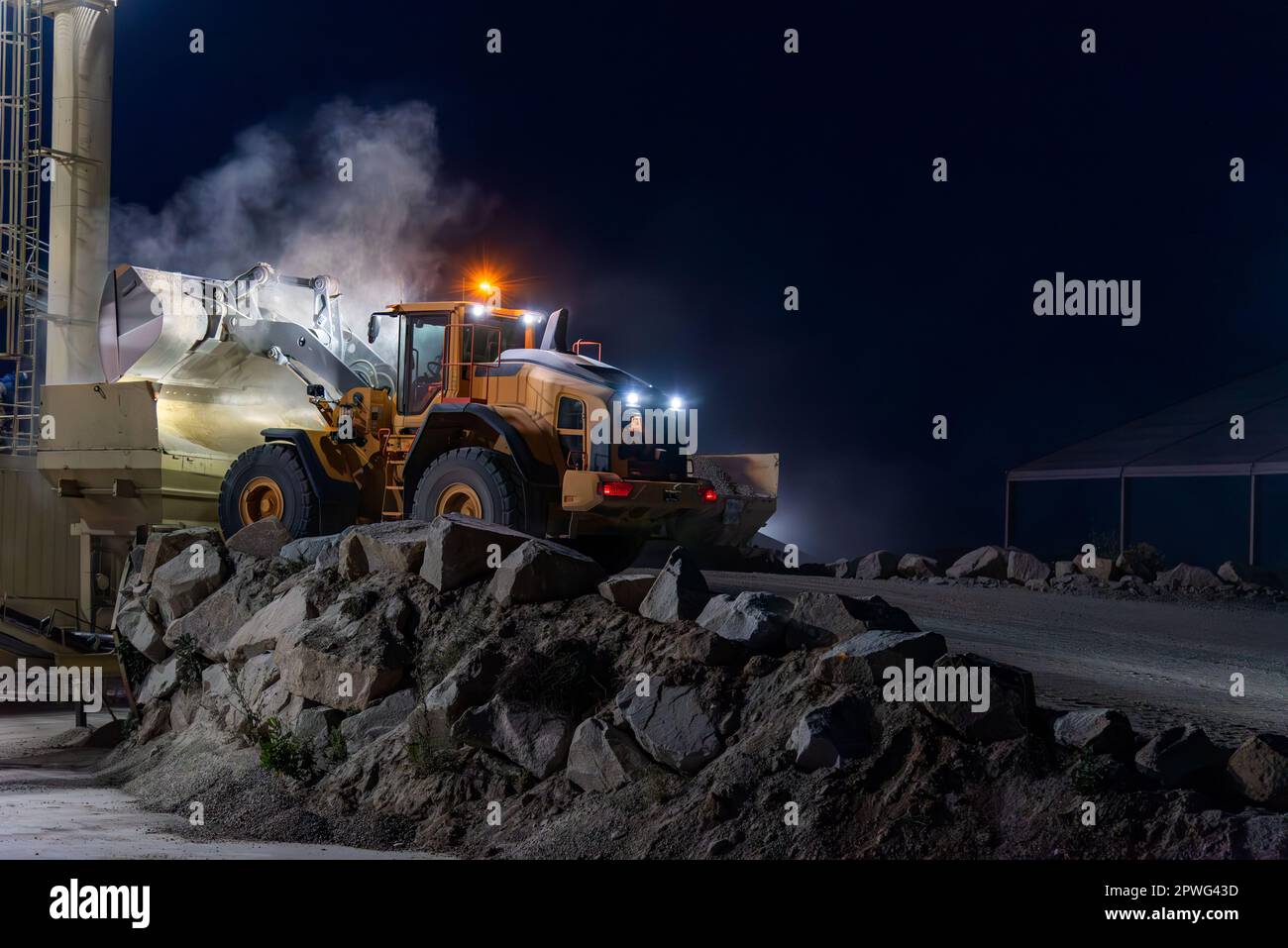 Heavy construction and mining machinery unloading gravel into silos on ...