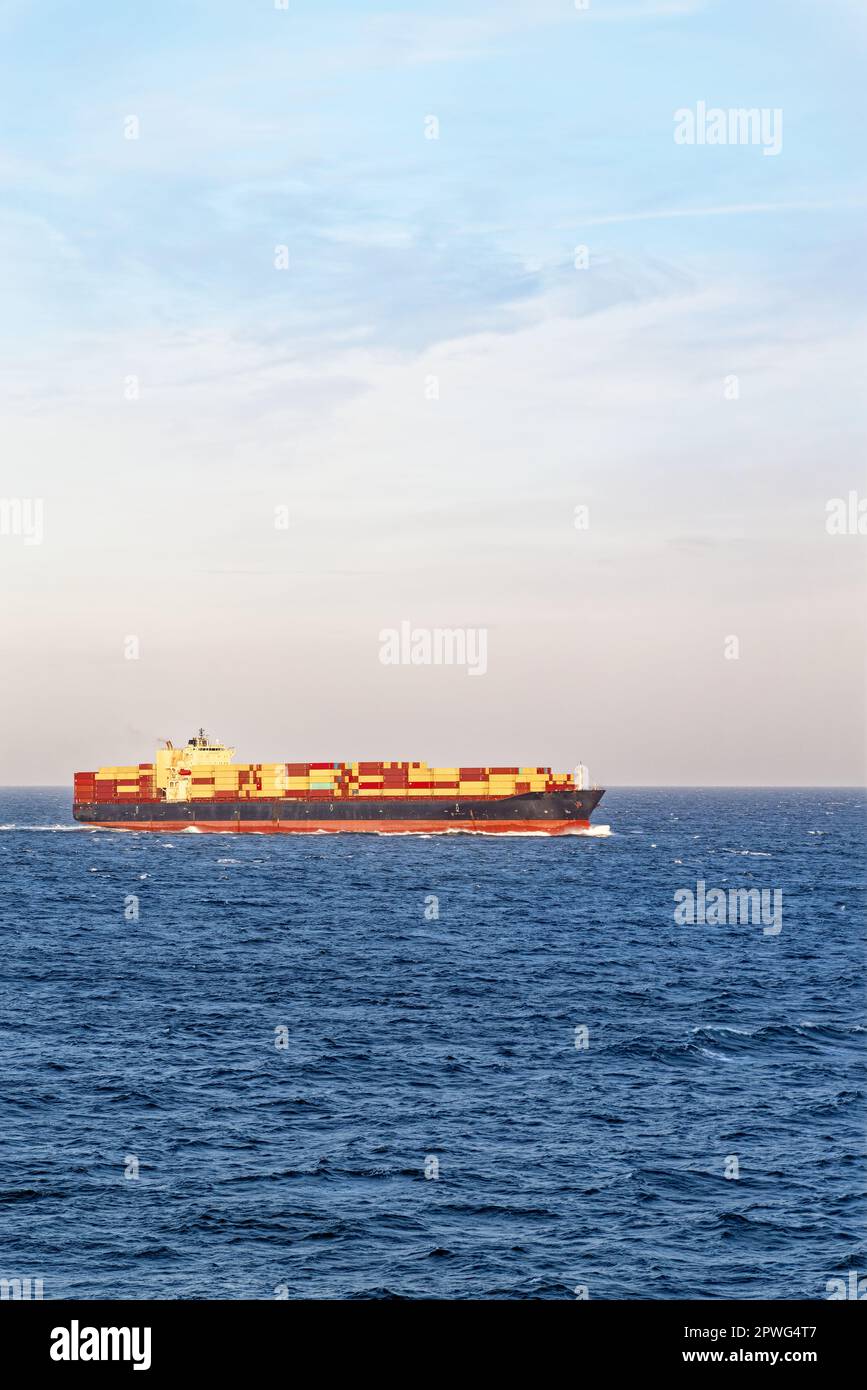 Scenic view of large cargo container ship sailing in open sea on sunny ...