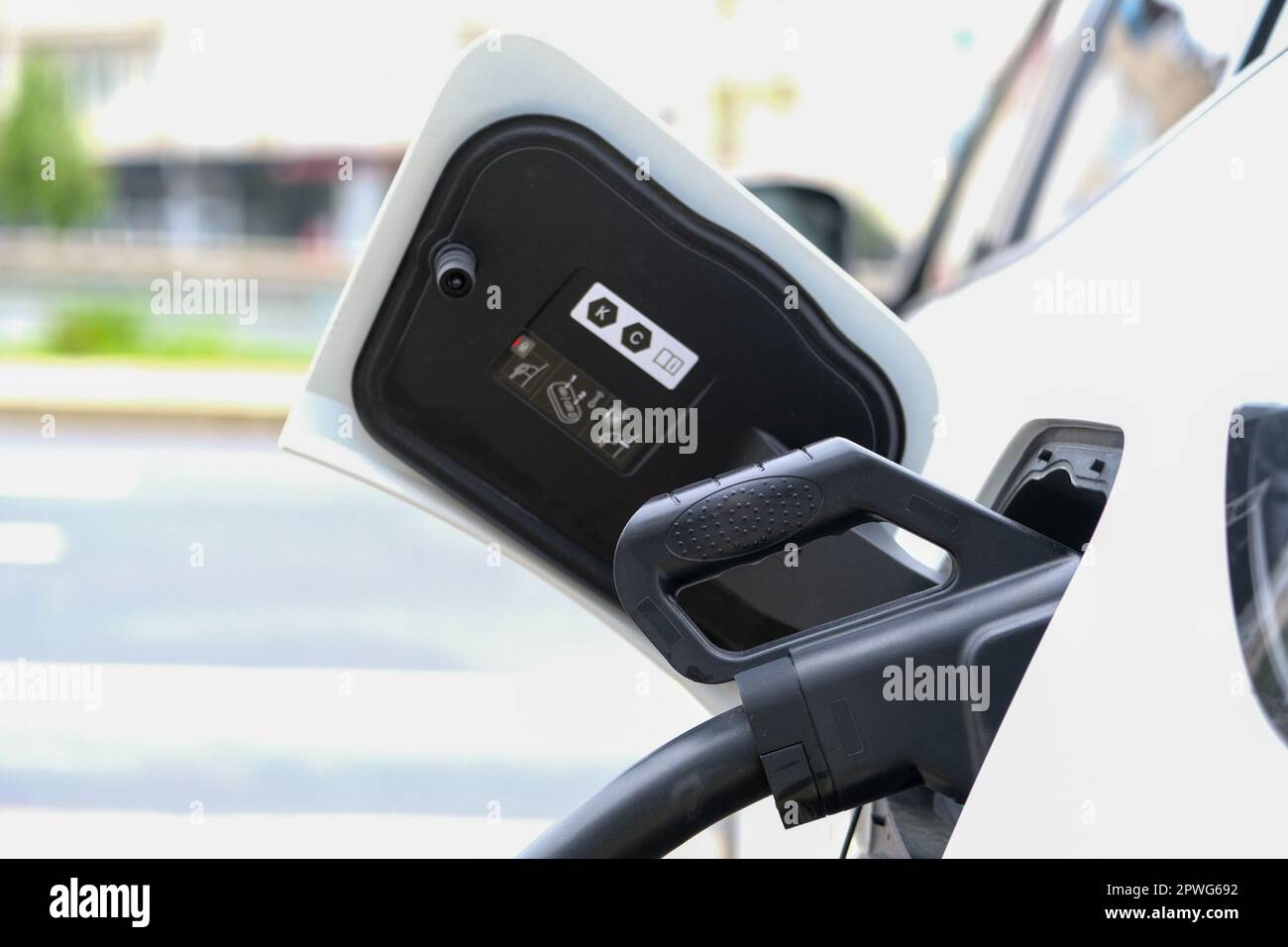 Close up charging white electric car. Electric car charging cable in ...