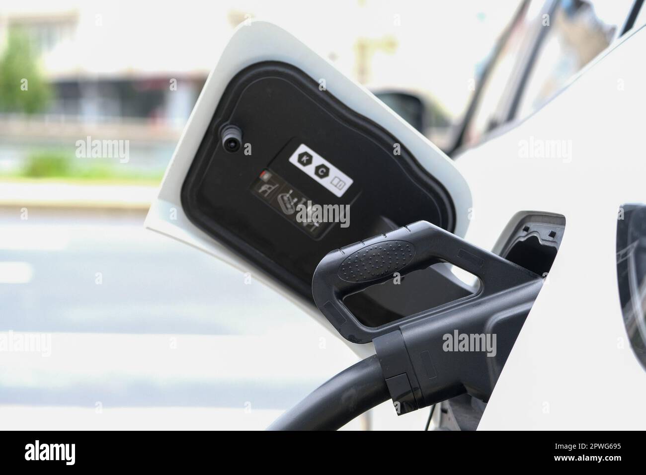 Close up charging white electric car. Electric car charging cable in ...