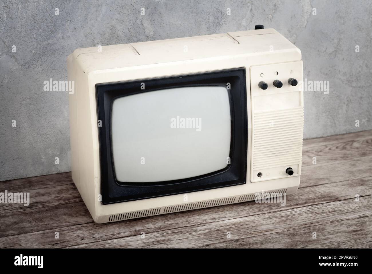 Vintage retro analog small TV set stand on wooden floor front grey ...