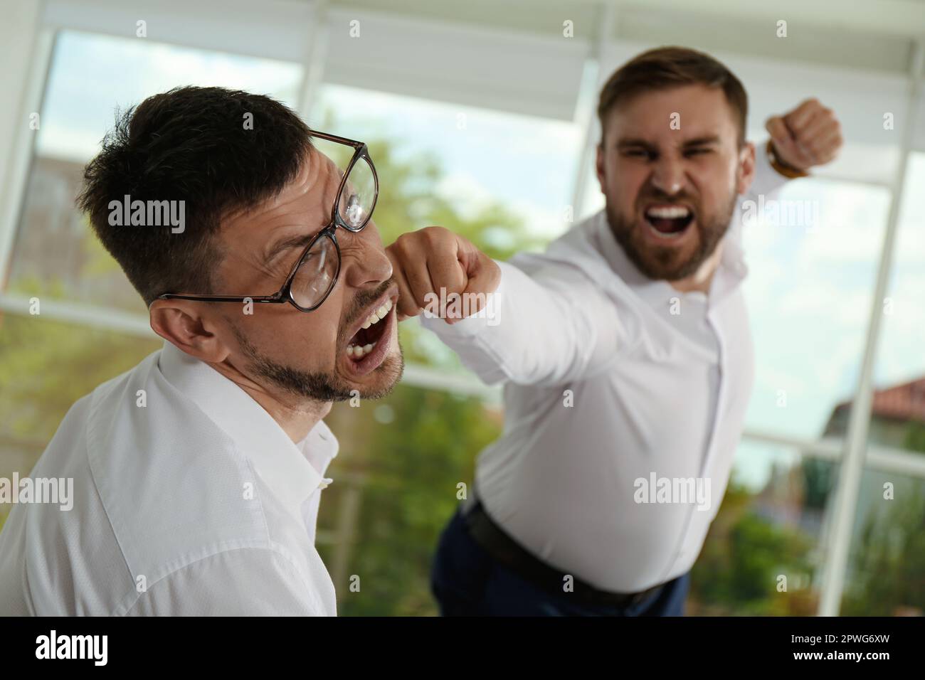 Emotional colleagues fighting in office. Workplace conflict Stock Photo ...