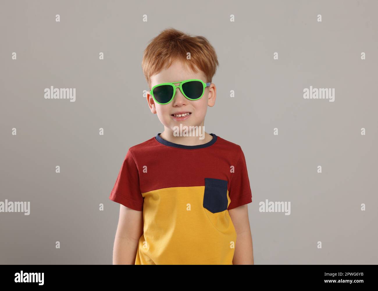 Cute little boy with sunglasses on light grey background Stock Photo ...