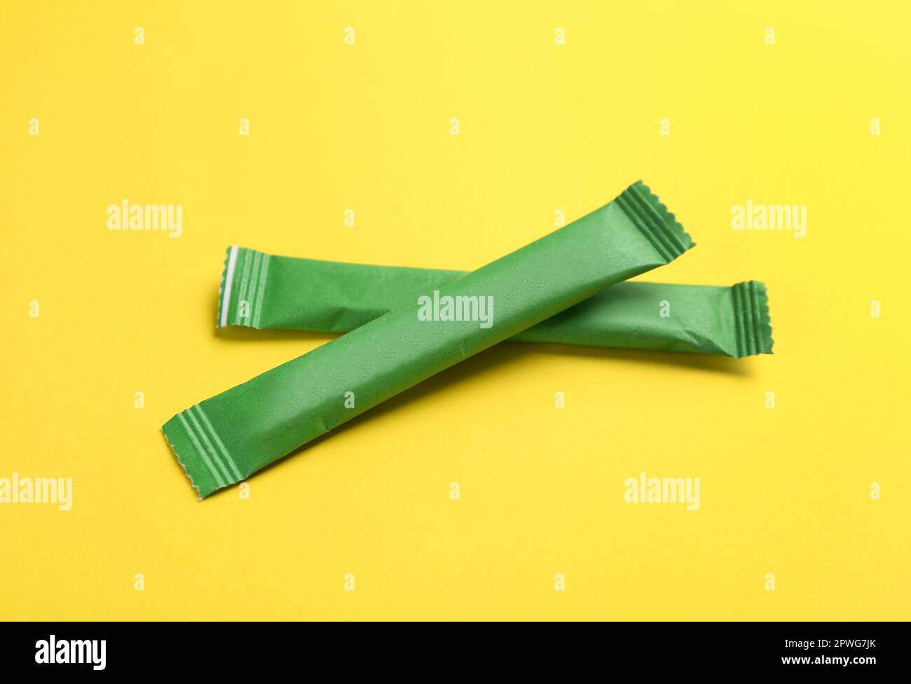 Green sticks of sugar on yellow background Stock Photo - Alamy