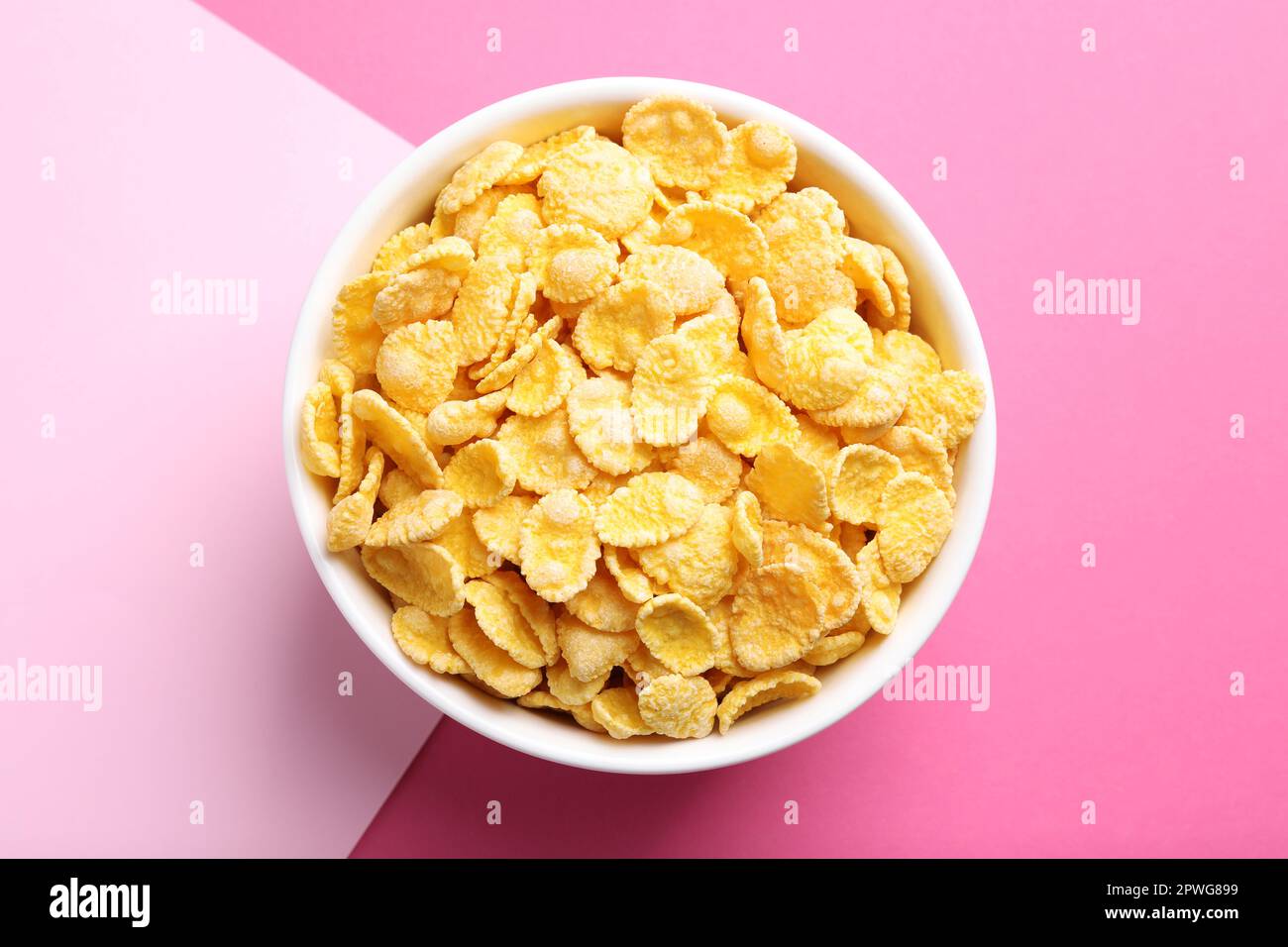 Bowl of tasty crispy corn flakes on pink background, top view Stock ...