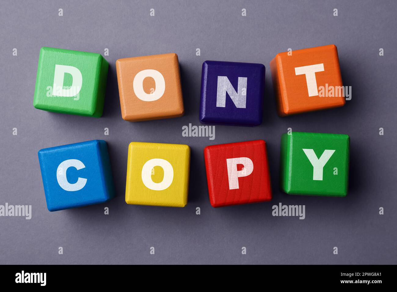 Colorful cubes with words Don't Copy on grey background, flat lay ...
