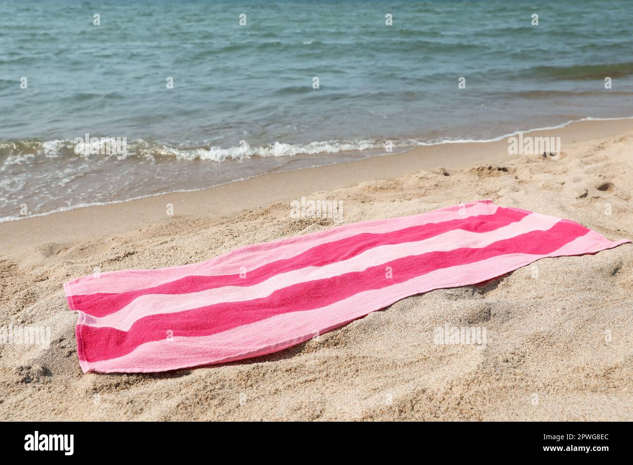Pink striped towel on beach sand near sea Stock Photo - Alamy