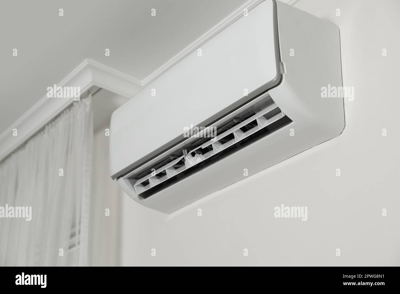 Modern air conditioner on white wall indoors Stock Photo - Alamy