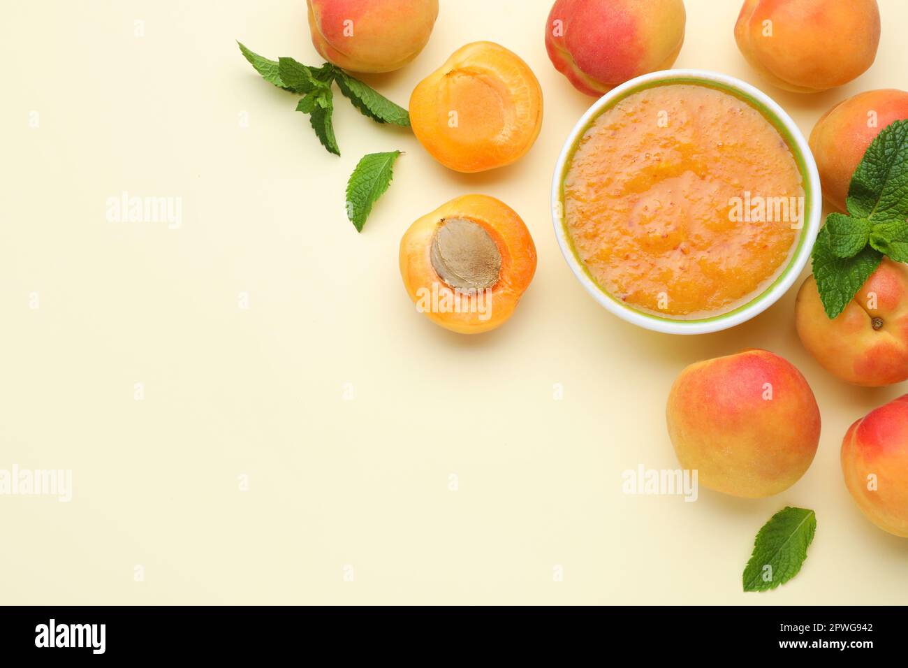 Apricot puree in bowl and fresh fruits on beige background, flat lay ...