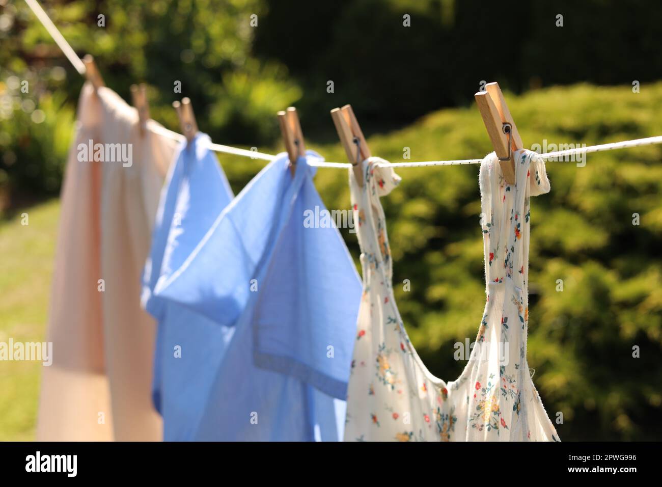 Clean clothes hanging on washing line in garden. Drying laundry Stock ...