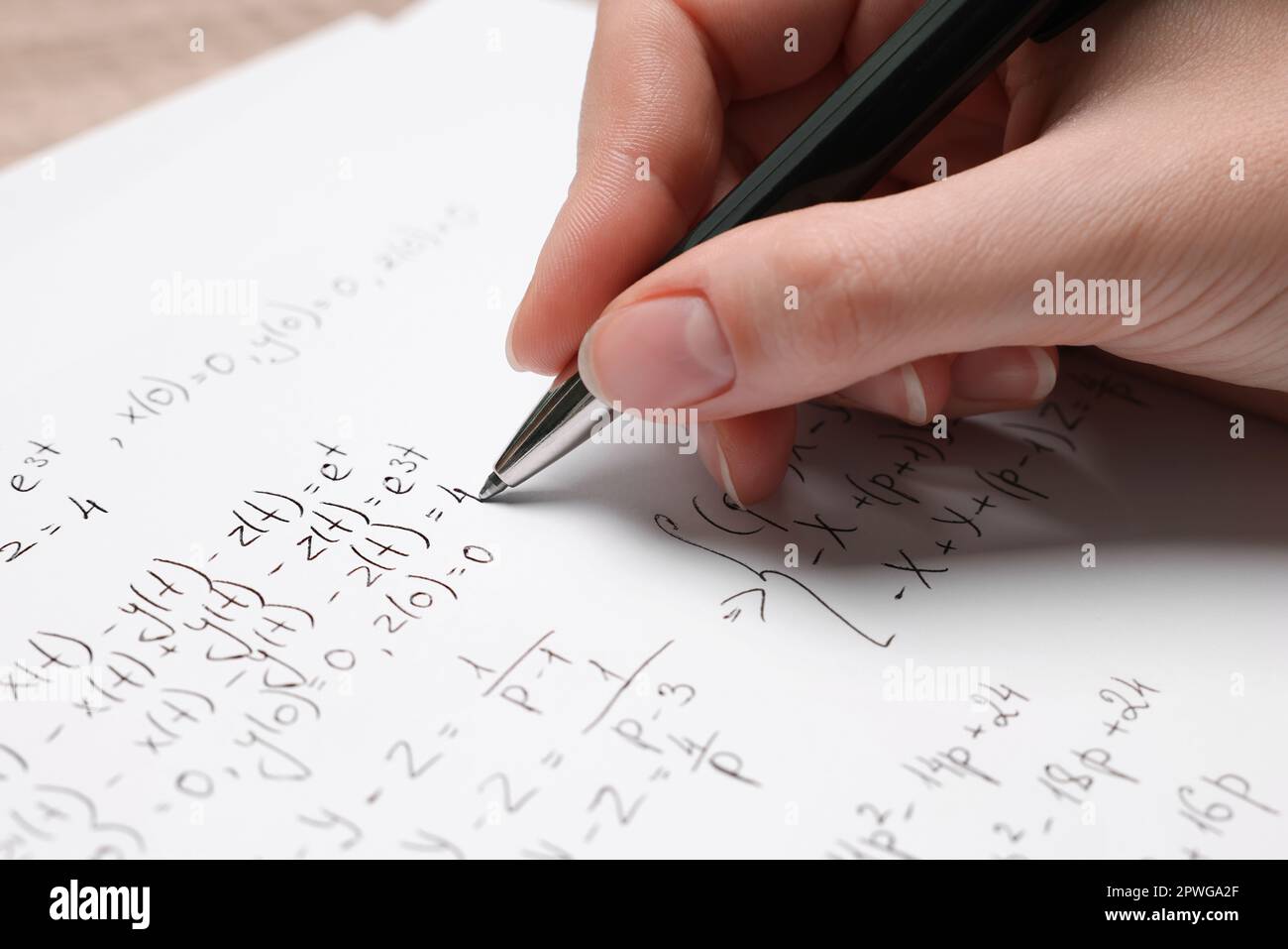 Student writing different mathematical formulas on paper, closeup Stock ...
