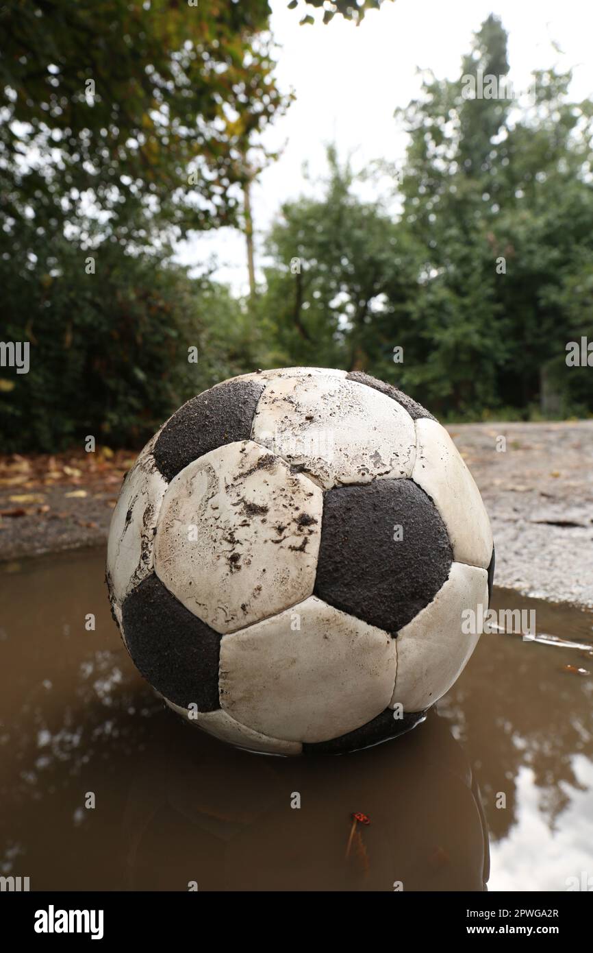 Dirty soccer ball in muddy puddle outdoors Stock Photo - Alamy