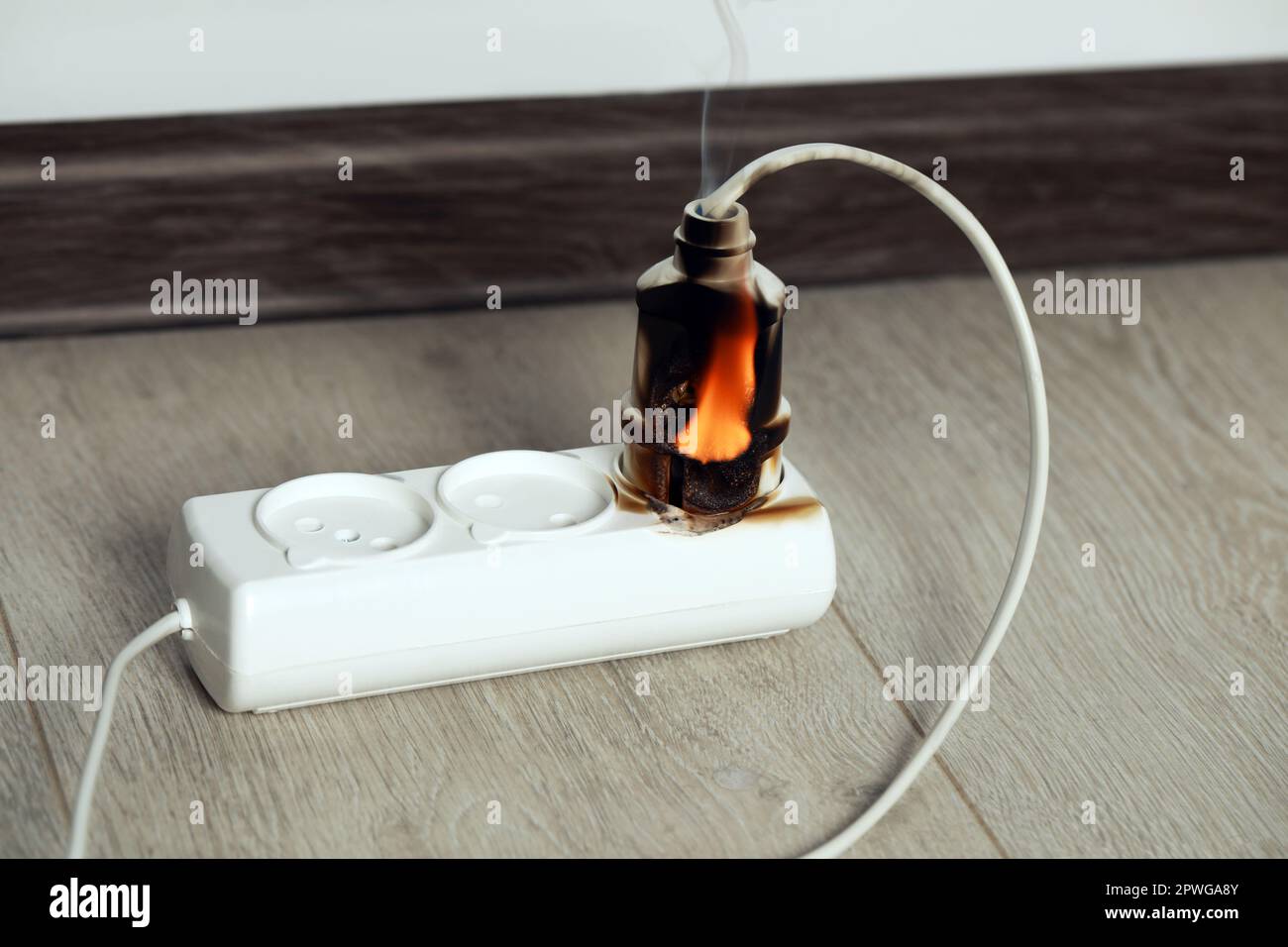 Inflamed plug in power strip indoors. Electrical short circuit Stock ...